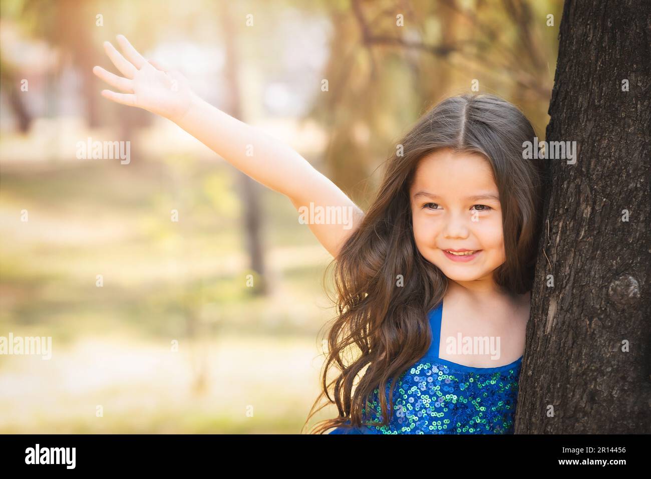 beautiful happy girl playing in the park with blue dress without shoes ...