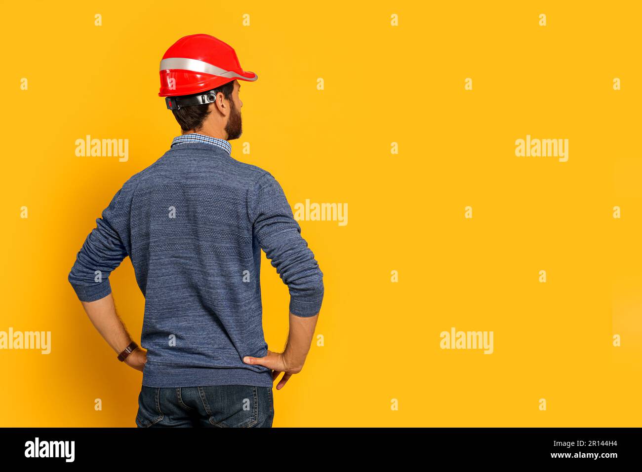 Professional engineer in hard hat on yellow background, back view. Space for text Stock Photo ...