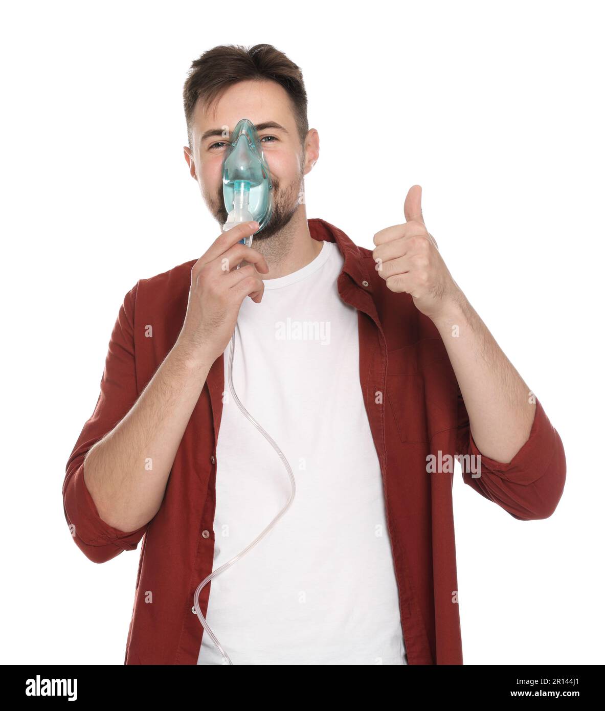 Man using nebulizer for inhalation and showing thumb up on white ...