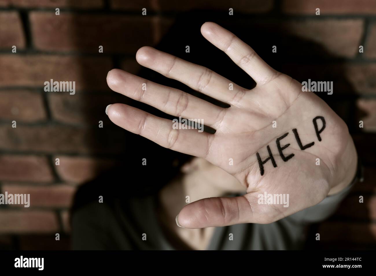 Domestic violence concept. Woman hiding her face, focus on hand with ...