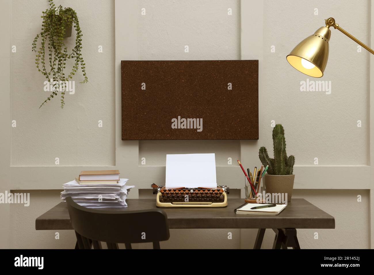 Typewriter and stack of papers on dark table in room. Writer's ...
