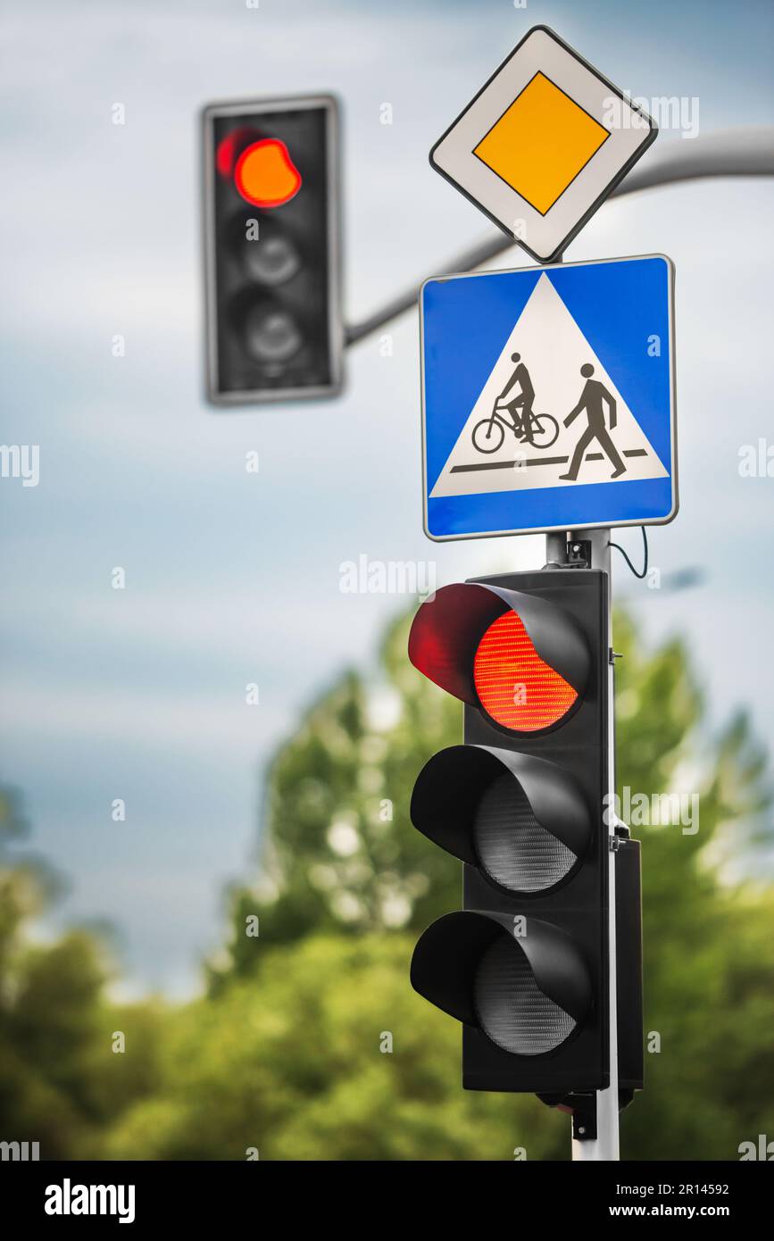 Post with Priority Road and Pedestrian crossing signs near traffic ...