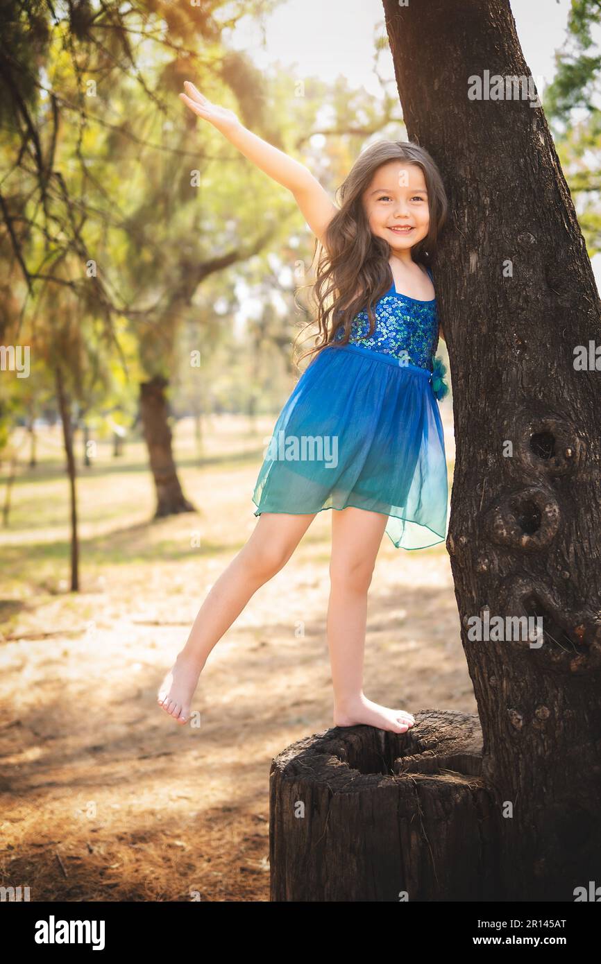 Beautiful Happy Girl Playing In The Park With Blue Dress Without Shoes