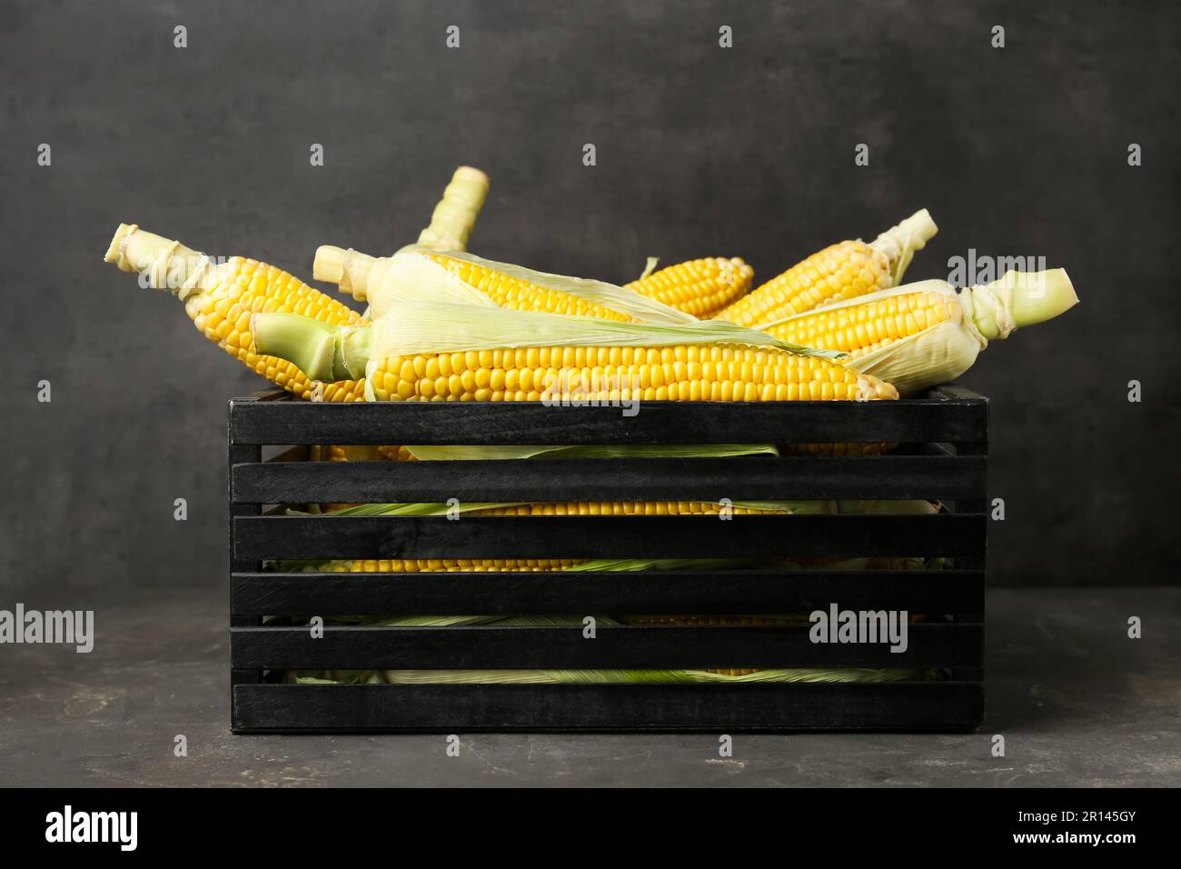 Wooden crate with tasty fresh corn cobs on grey table Stock Photo - Alamy