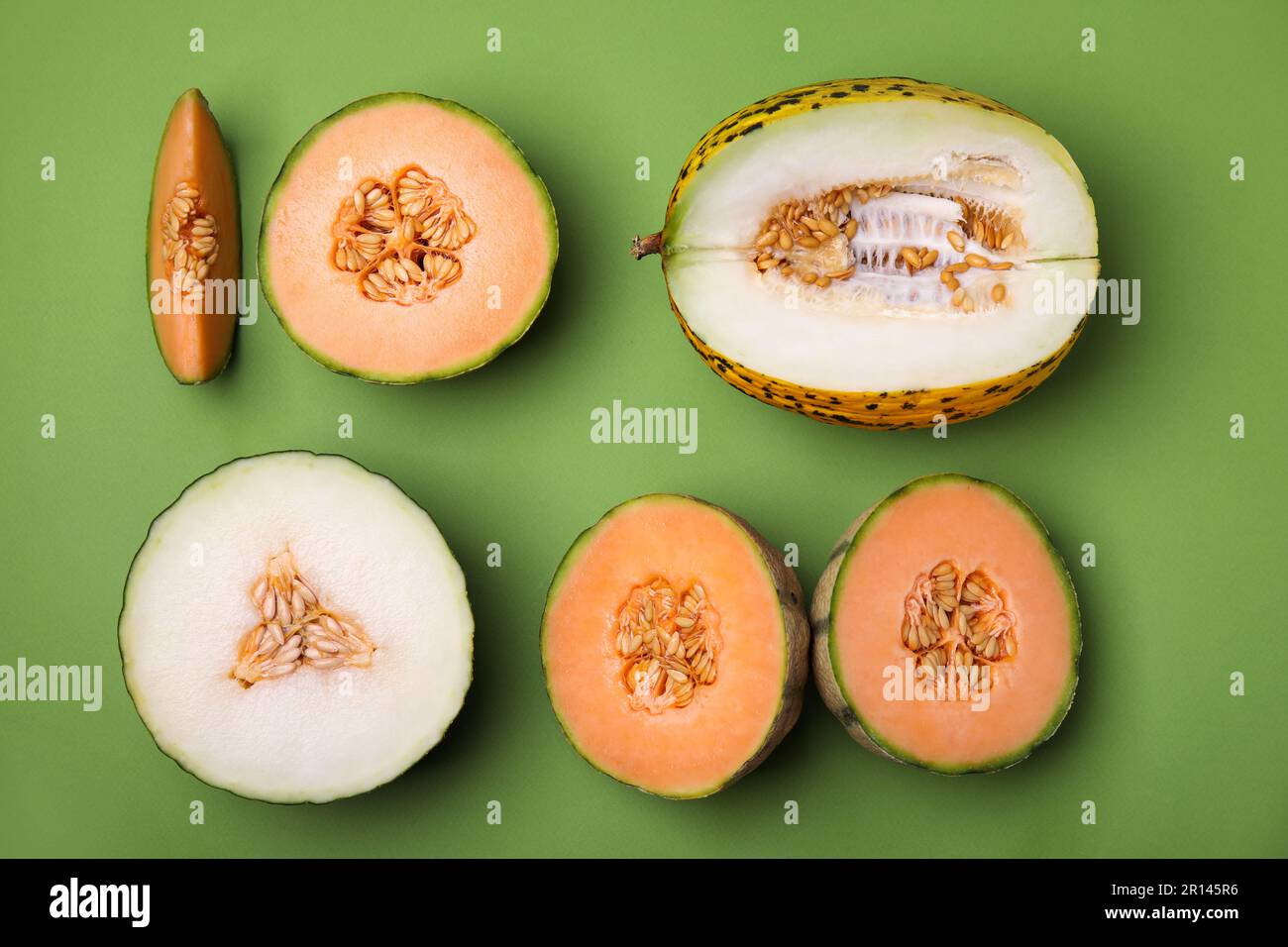 Cut different types of melons on green background, flat lay Stock Photo ...