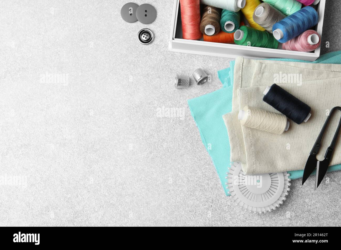 Flat lay composition with spools of threads and sewing tools on light ...