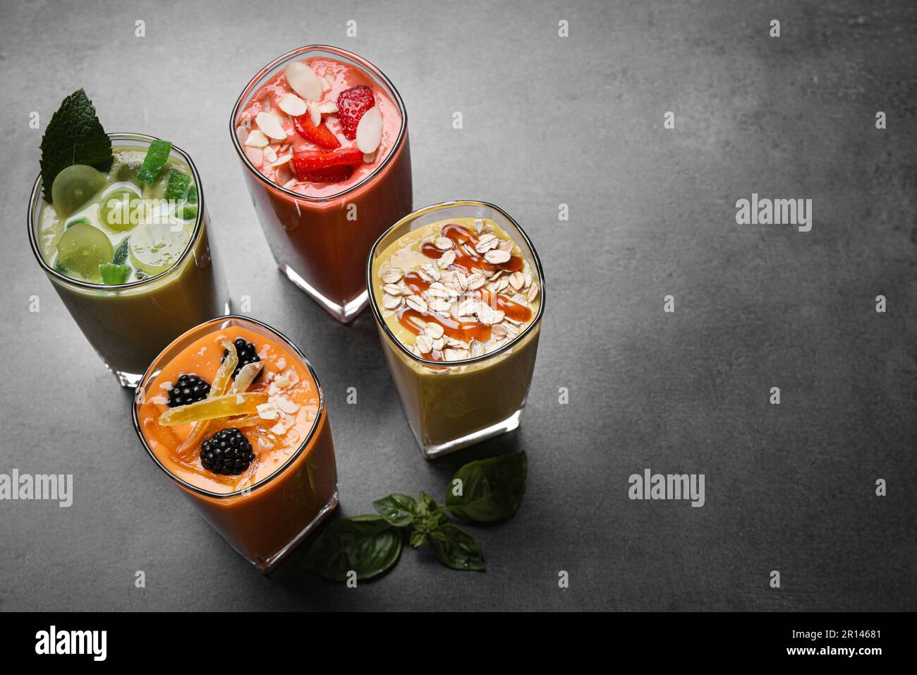 Many different delicious smoothies on grey table, above view. Space for ...