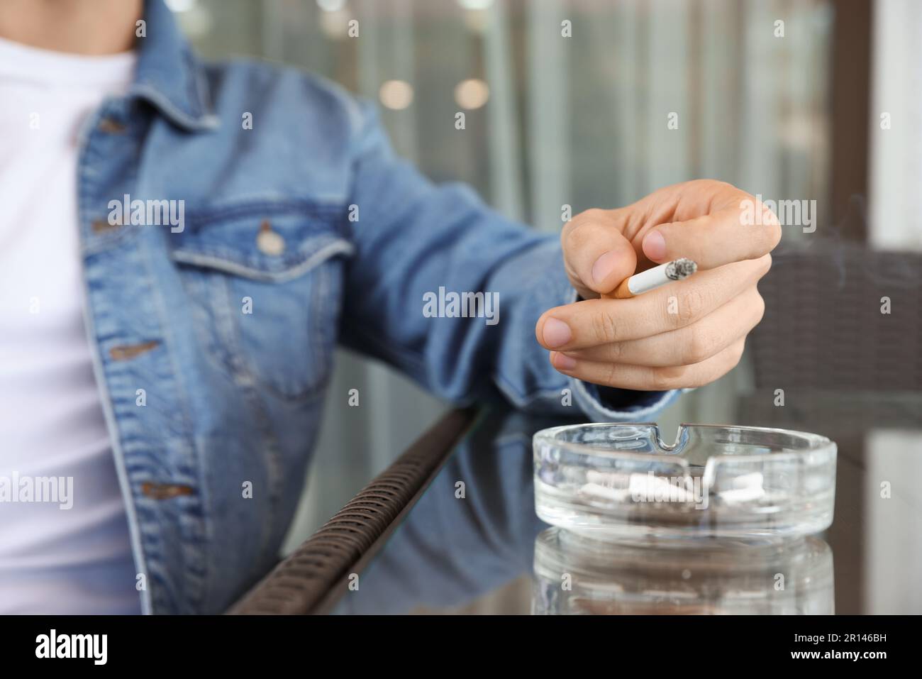 Man smoking cigarette at table in outdoor cafe, closeup Stock Photo - Alamy