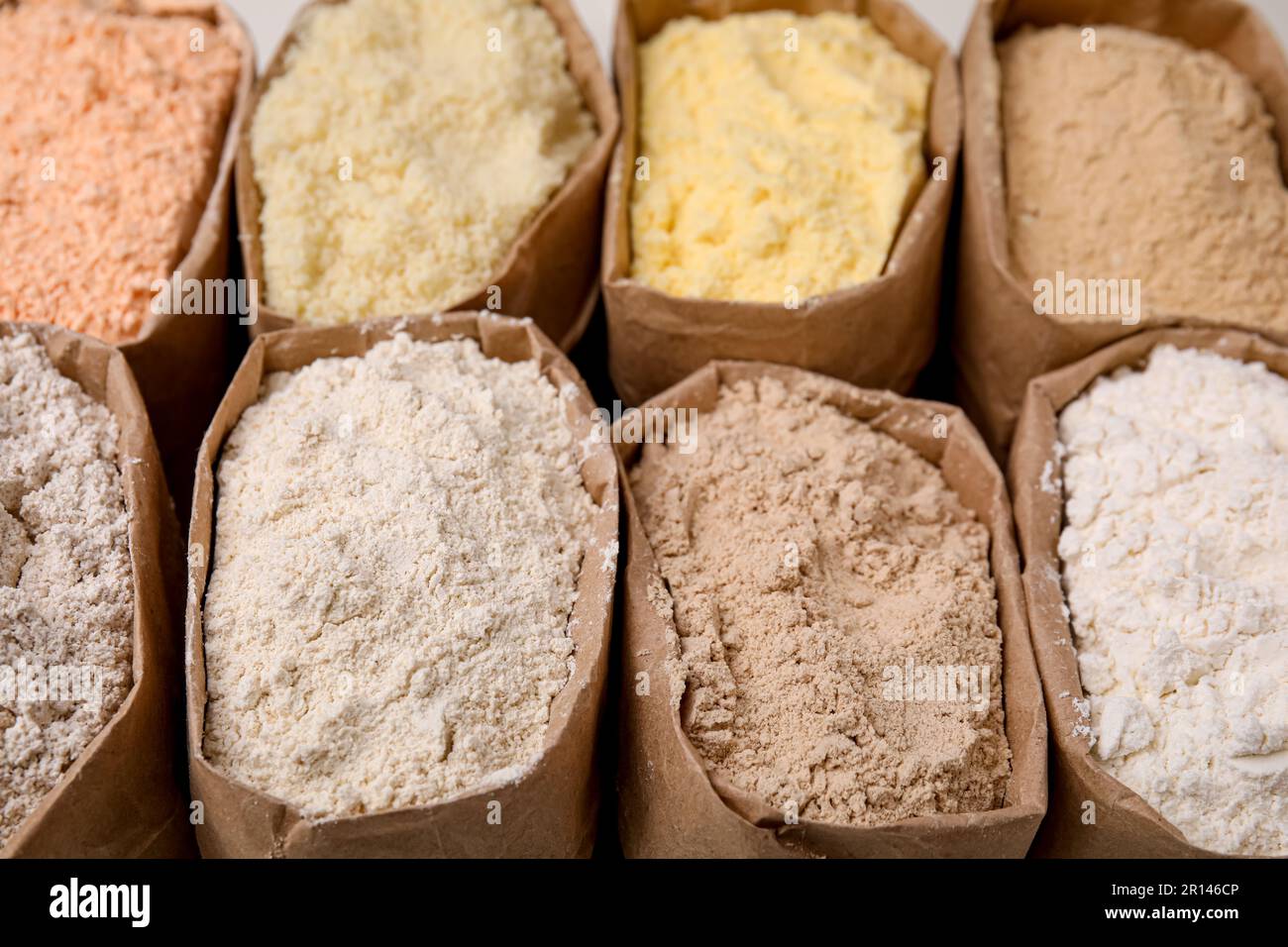 Paper sacks with different types of flour as background, closeup Stock ...