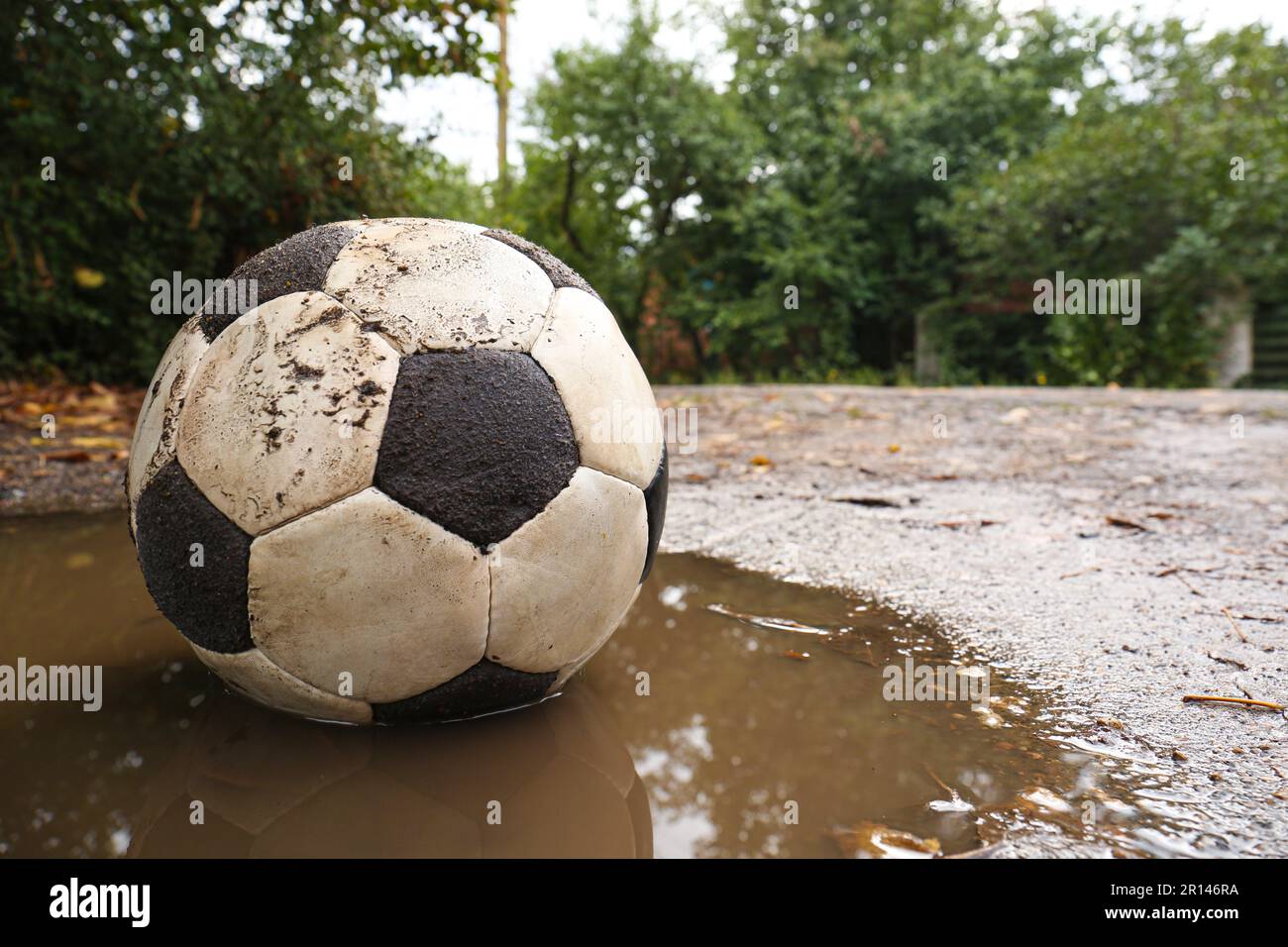 Dirty soccer ball in muddy puddle, space for text Stock Photo - Alamy