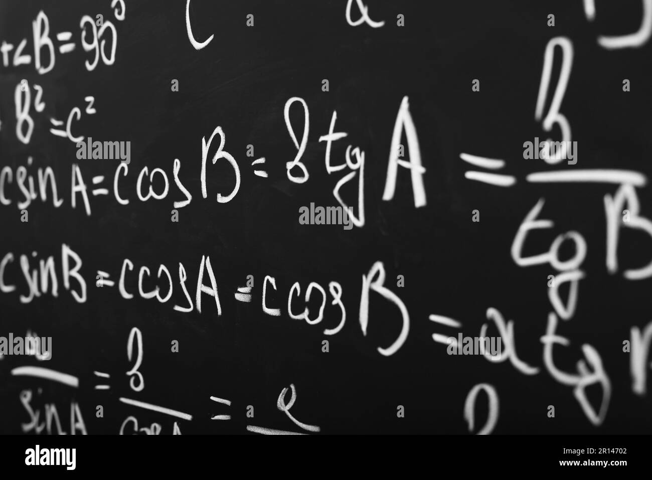 Different mathematical formulas written with chalk on blackboard ...