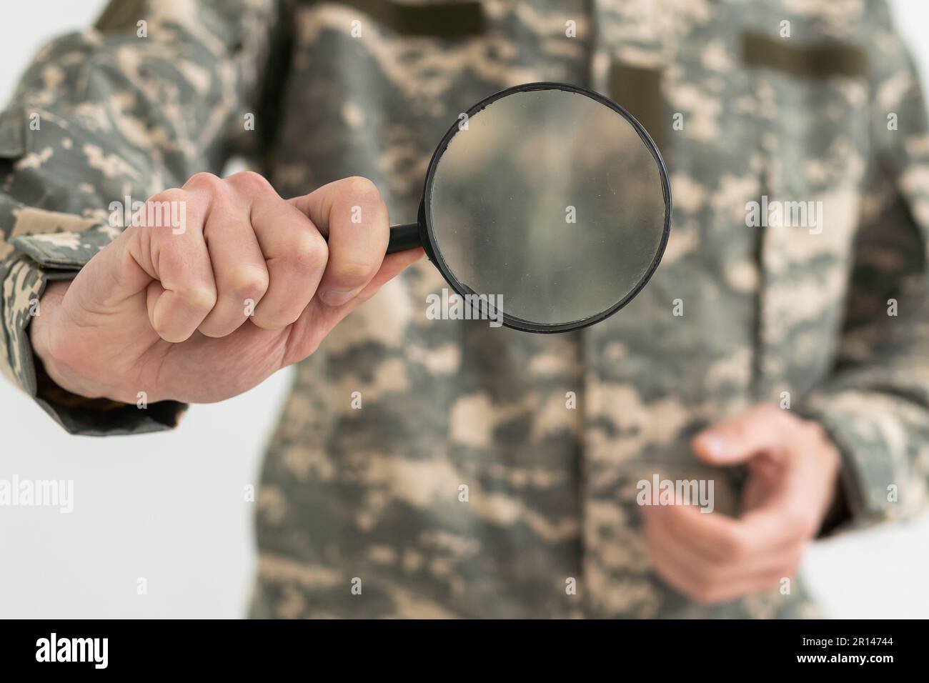 military man holding a magnifying glass Stock Photo - Alamy