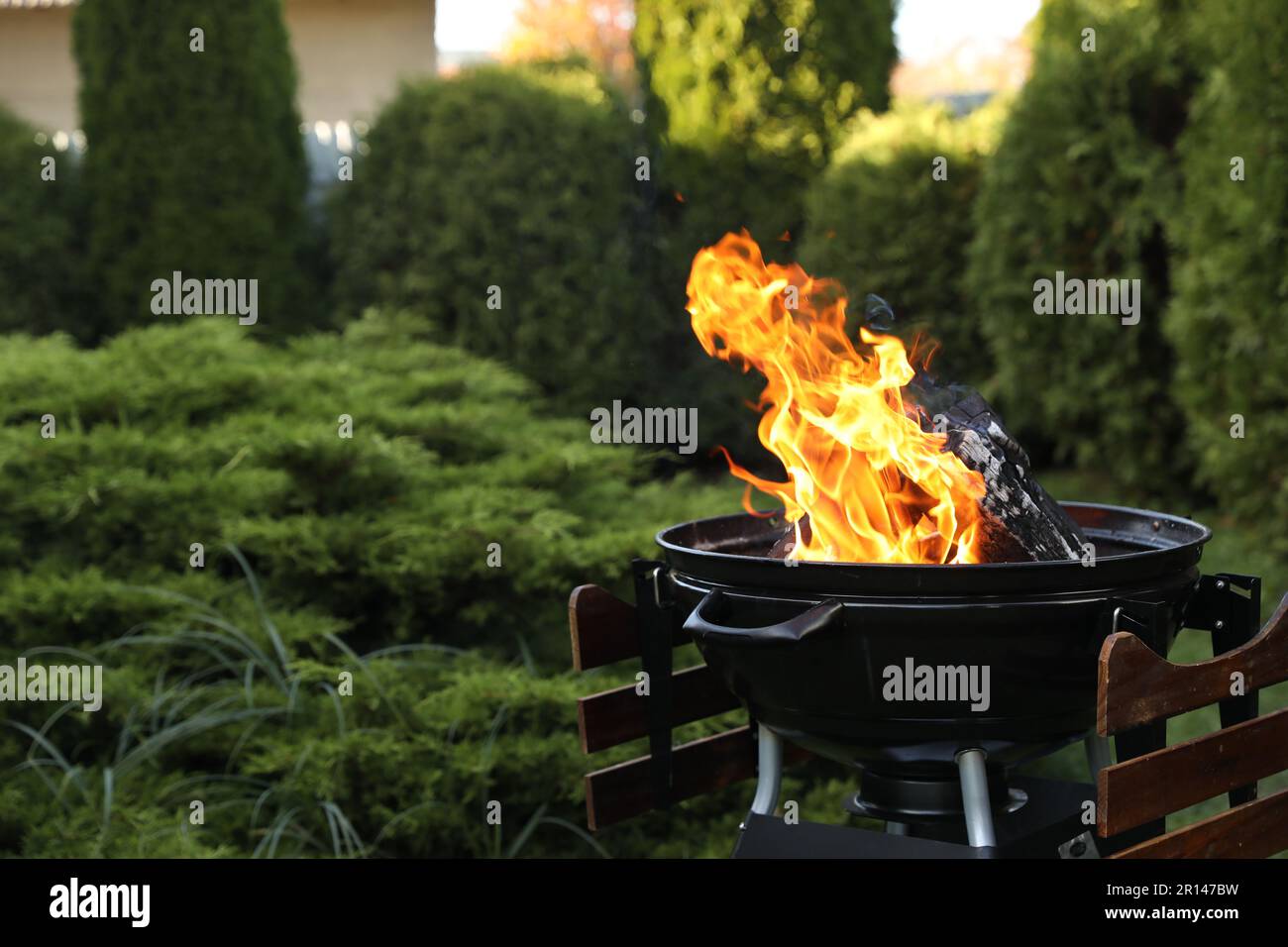 Portable barbecue grill with fire flames outdoors. Space for text Stock ...