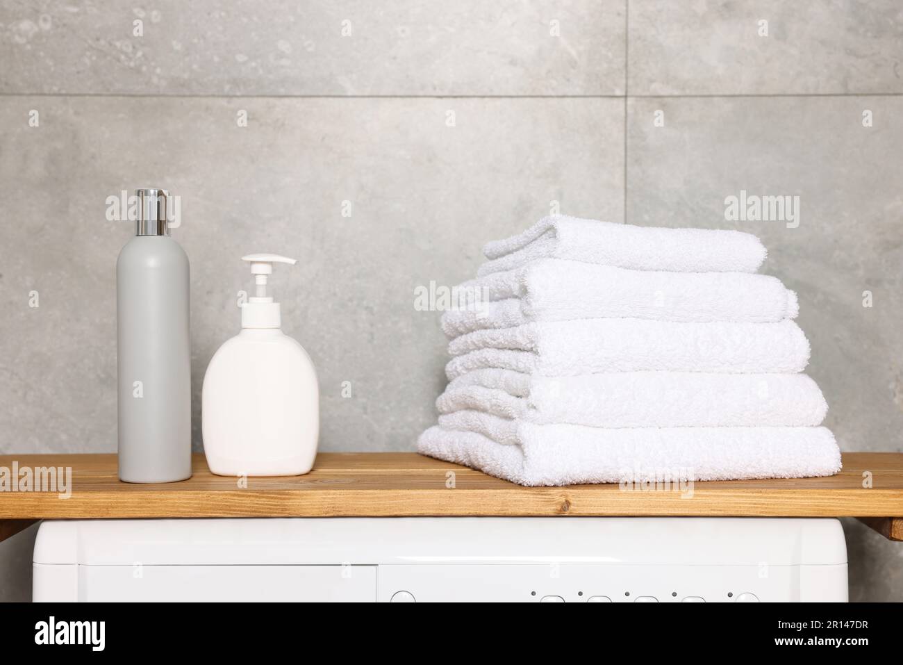 Stack of clean towels and cosmetic products in laundry room Stock Photo ...