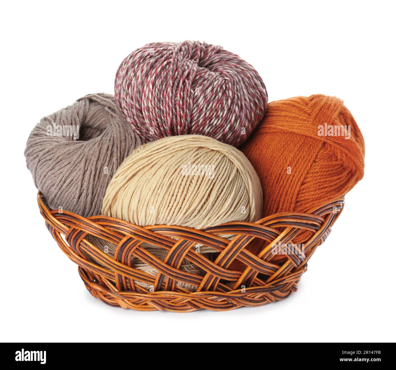 Different balls of woolen knitting yarns in wicker basket on white ...