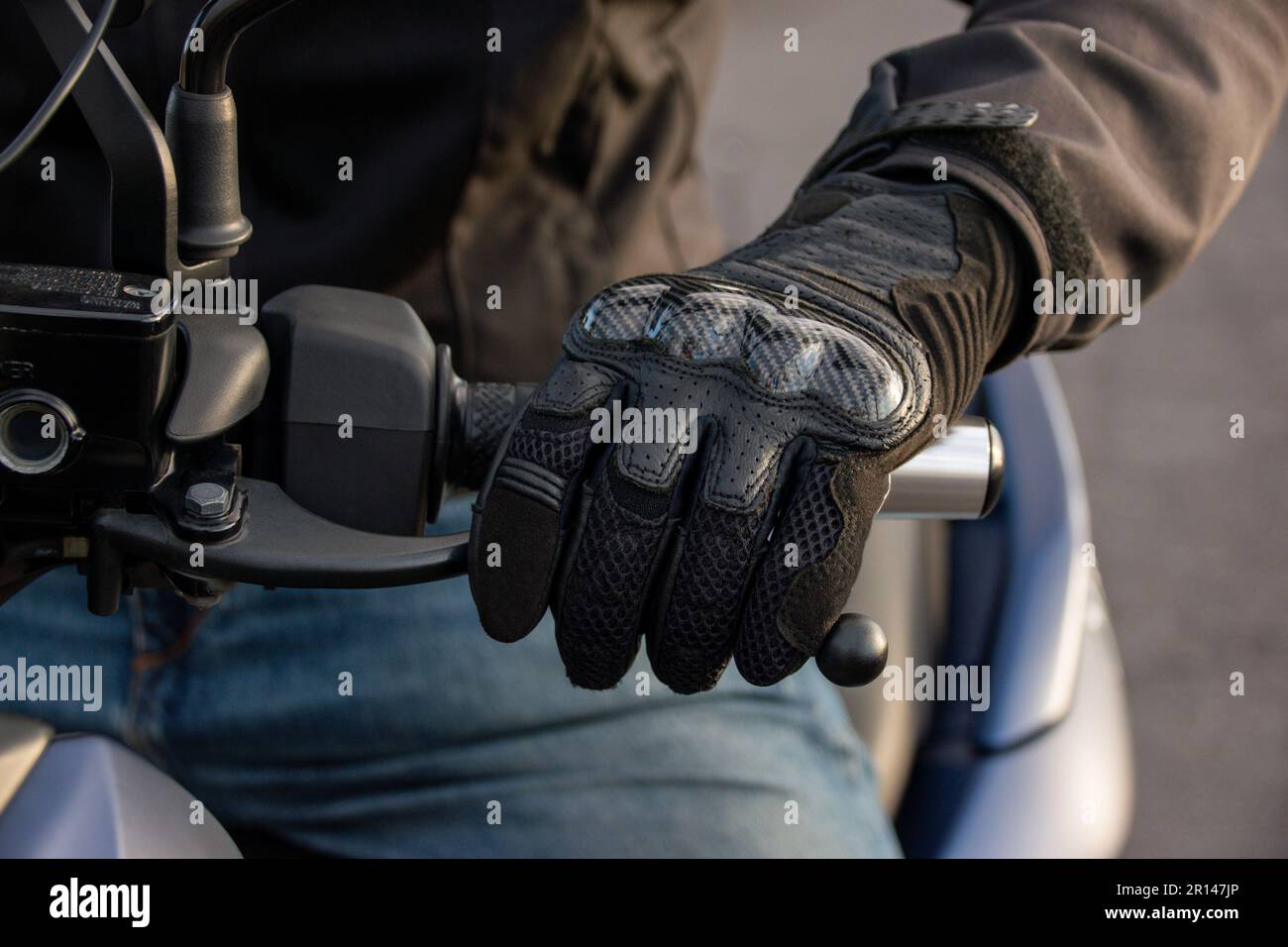 Close-up of a gloved biker's hand pulling the brake of his motorcycle ...