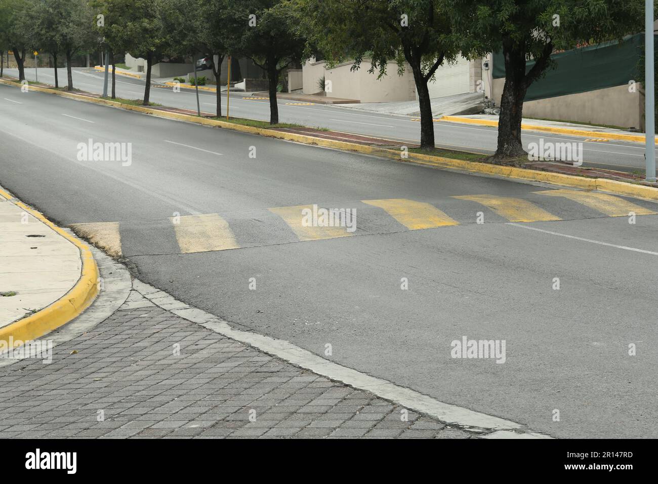 City street with striped concrete speed bump Stock Photo - Alamy