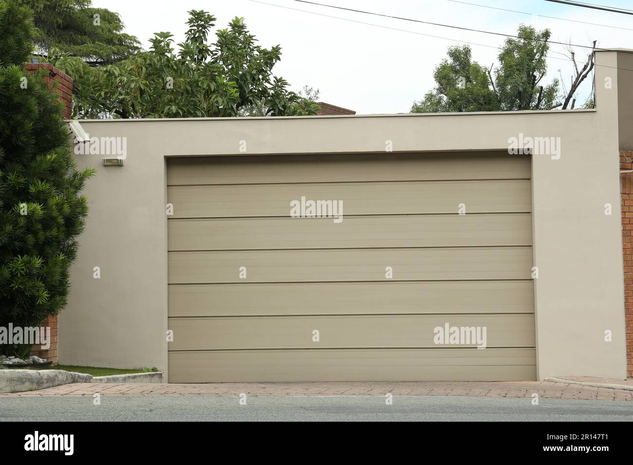 Beige garage with closed sectional door. Exterior design Stock Photo ...