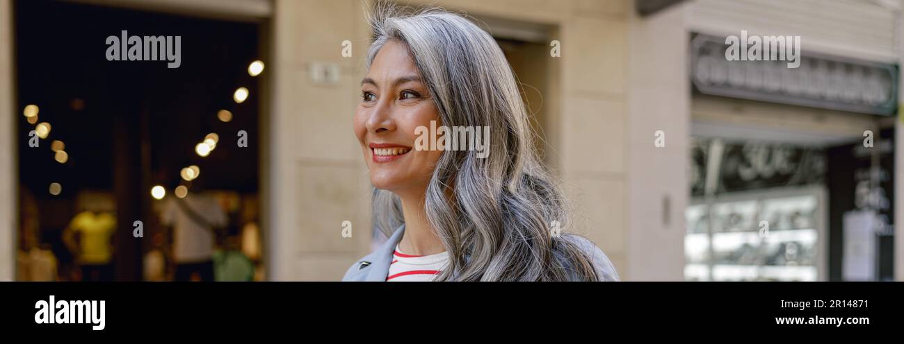 Busy mature lady taking stroll through city Stock Photo - Alamy