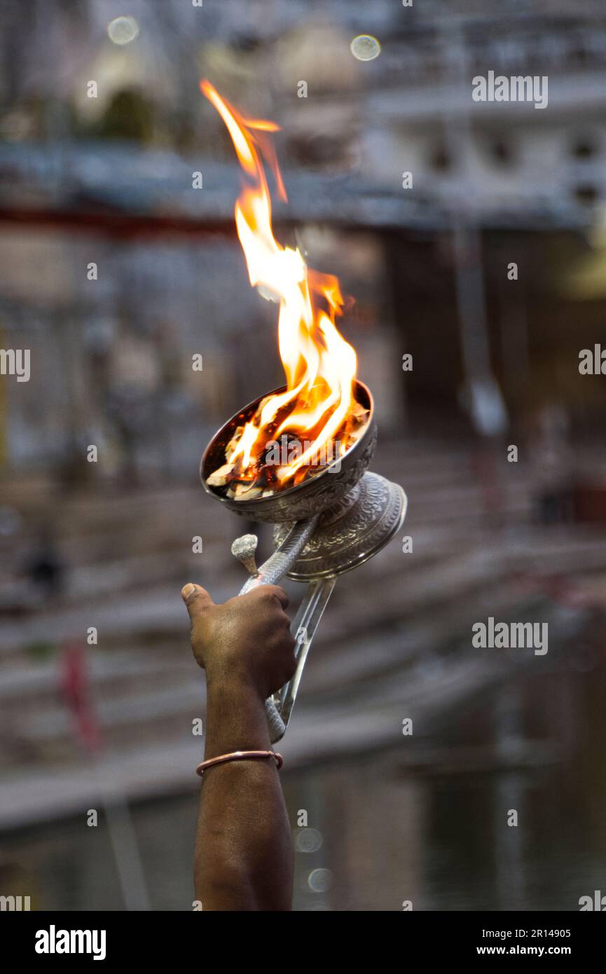 Hand of a man raising the religious fire and praying in hope of ...