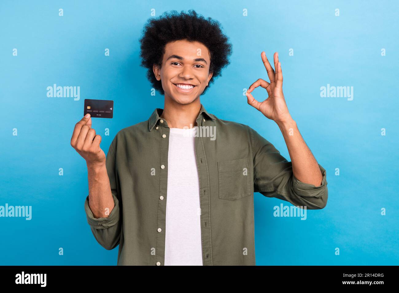 Photo of funny handsome guy hold debit card demonstrate okey symbol ...