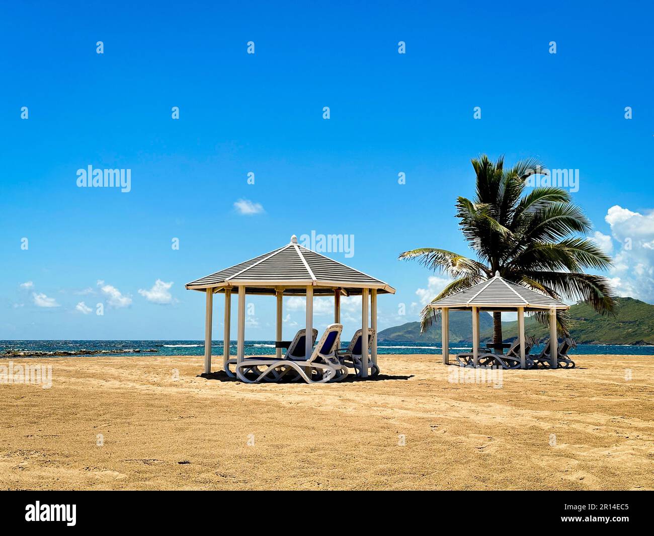 Relaxing Tropical vacation with beach cabana and palm tree under a blue ...
