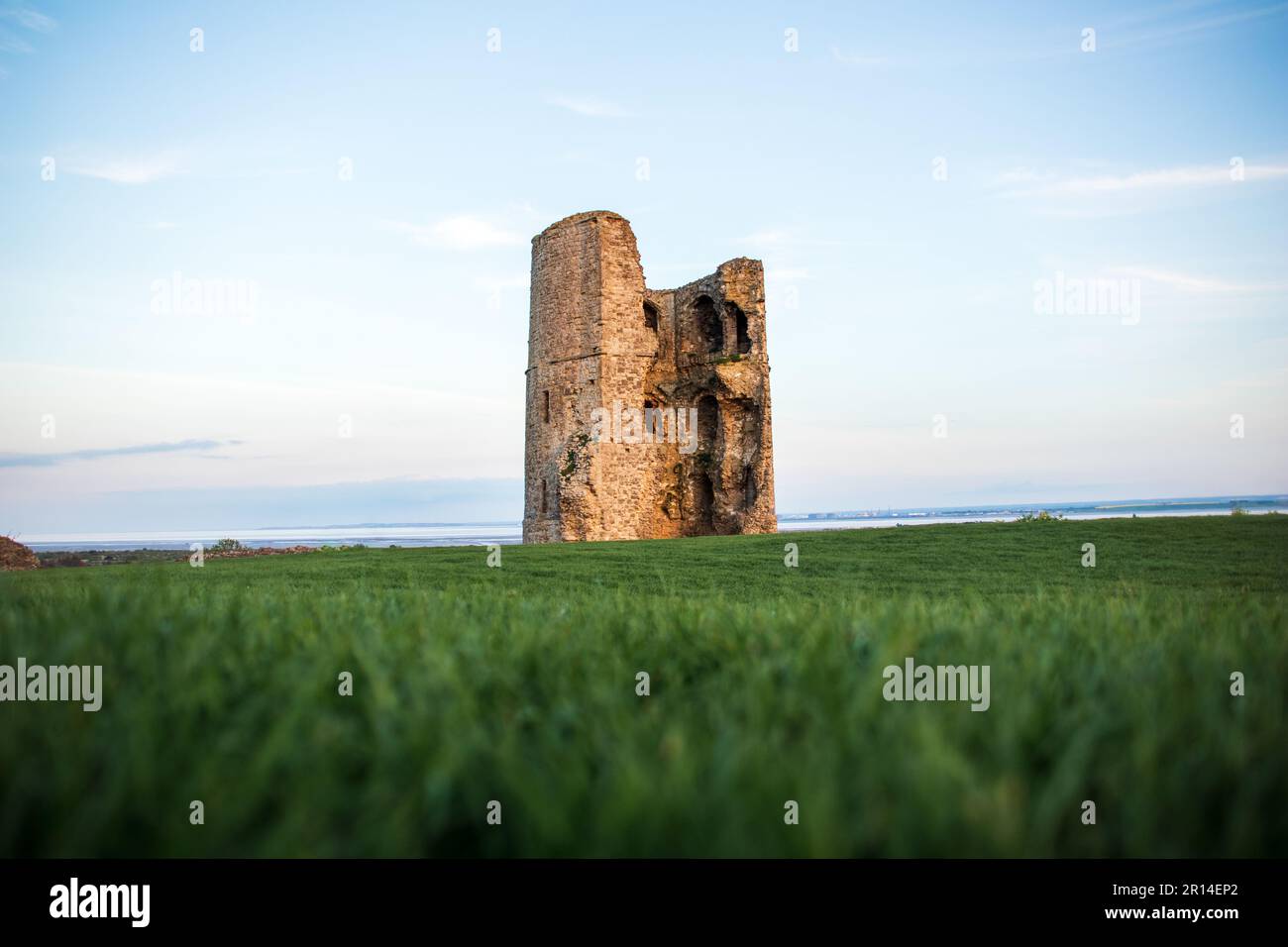 The Hadley Castle in a grassy meadow with blue sky in the background ...