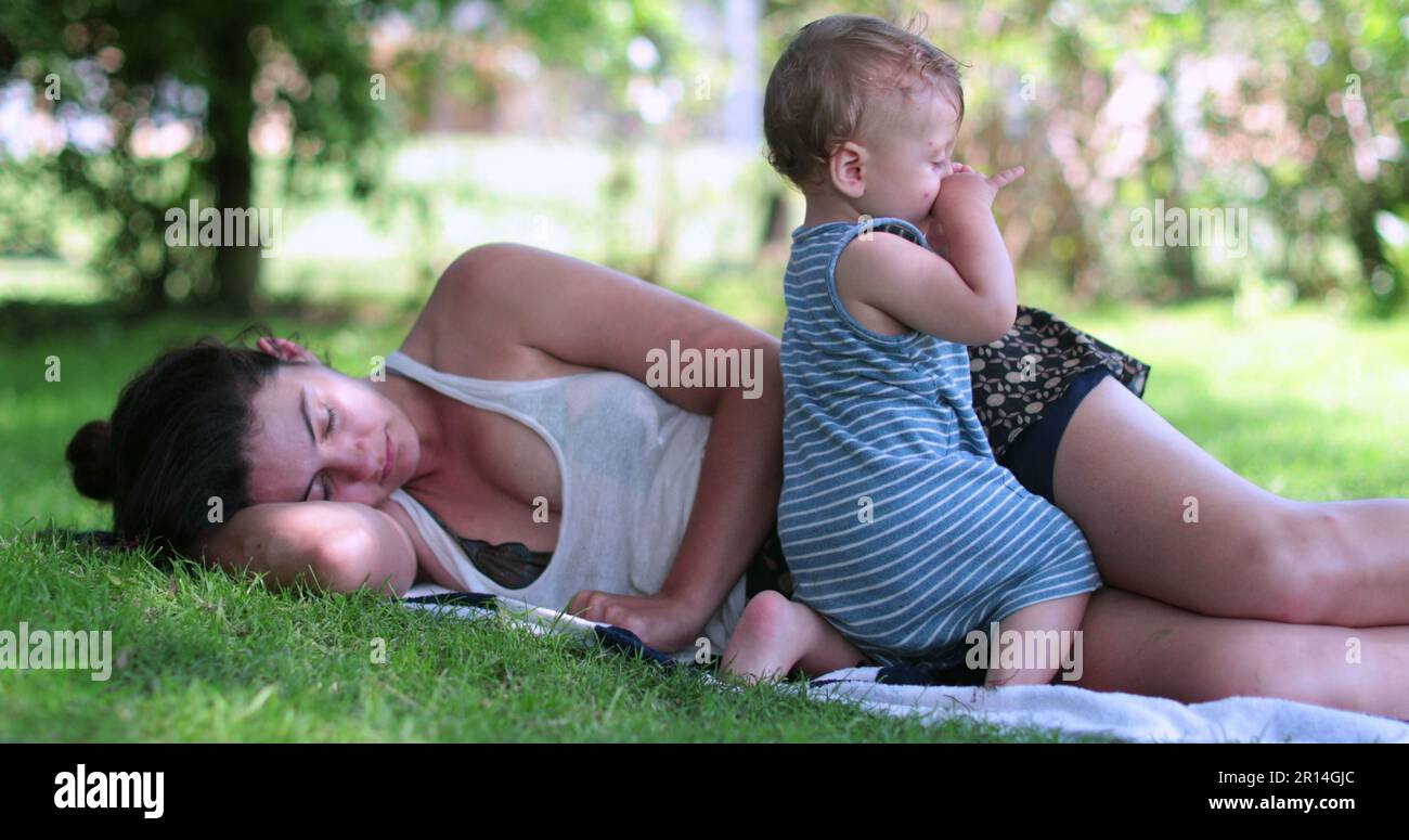 Tired exhausted mother sleeping lying on grass Stock Photo - Alamy