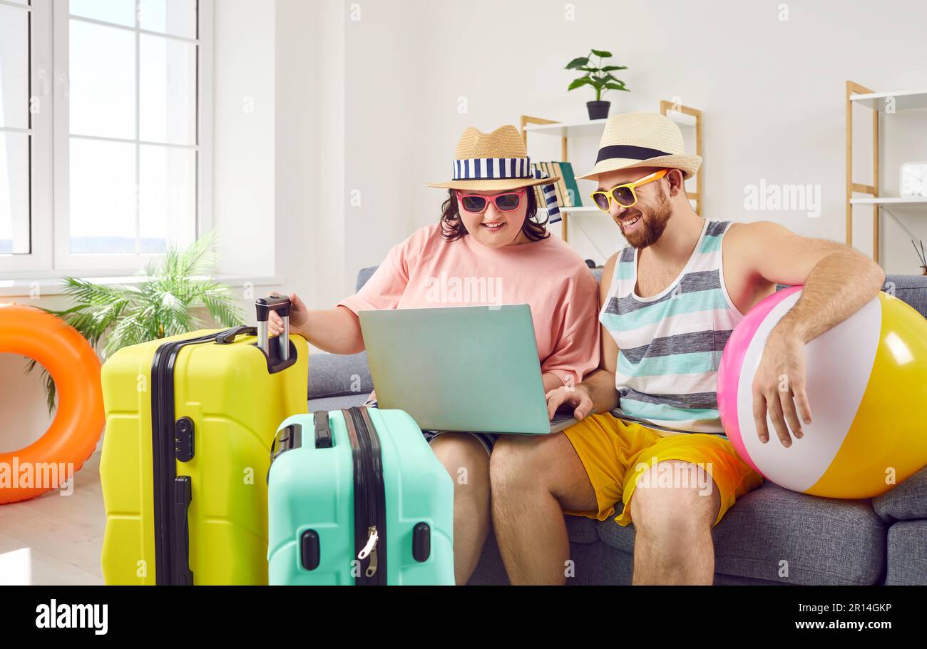 Happy family couple using laptop and booking tickets and hotel for ...