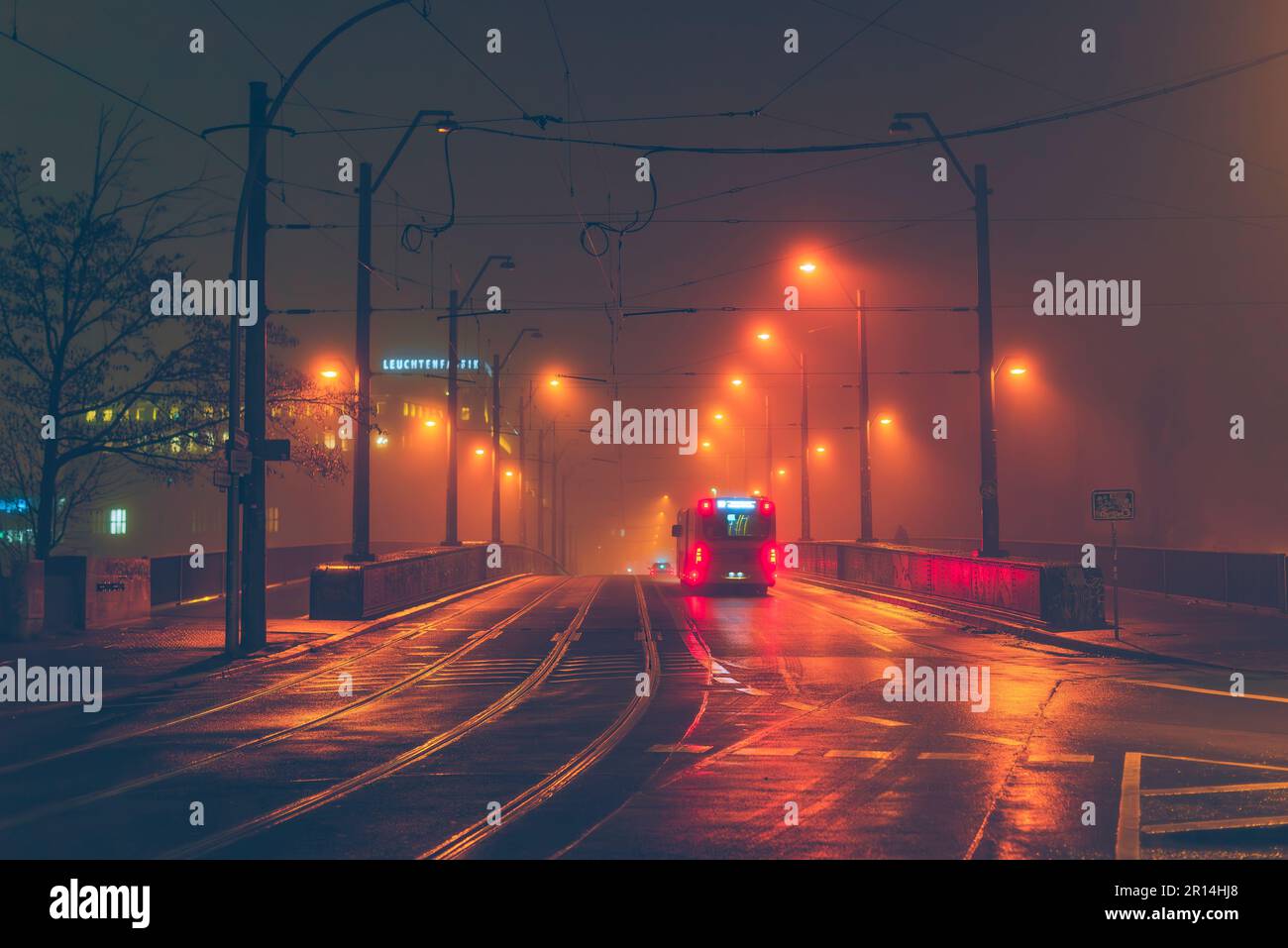 Traffic on a foggy wet bridge, a brightly lit bridge in foggy weather ...