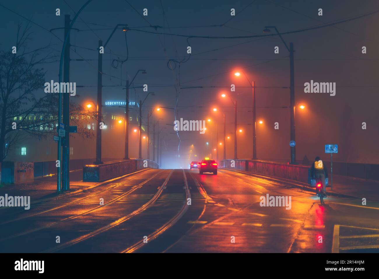 Traffic on a foggy wet bridge, a brightly lit bridge in foggy weather ...
