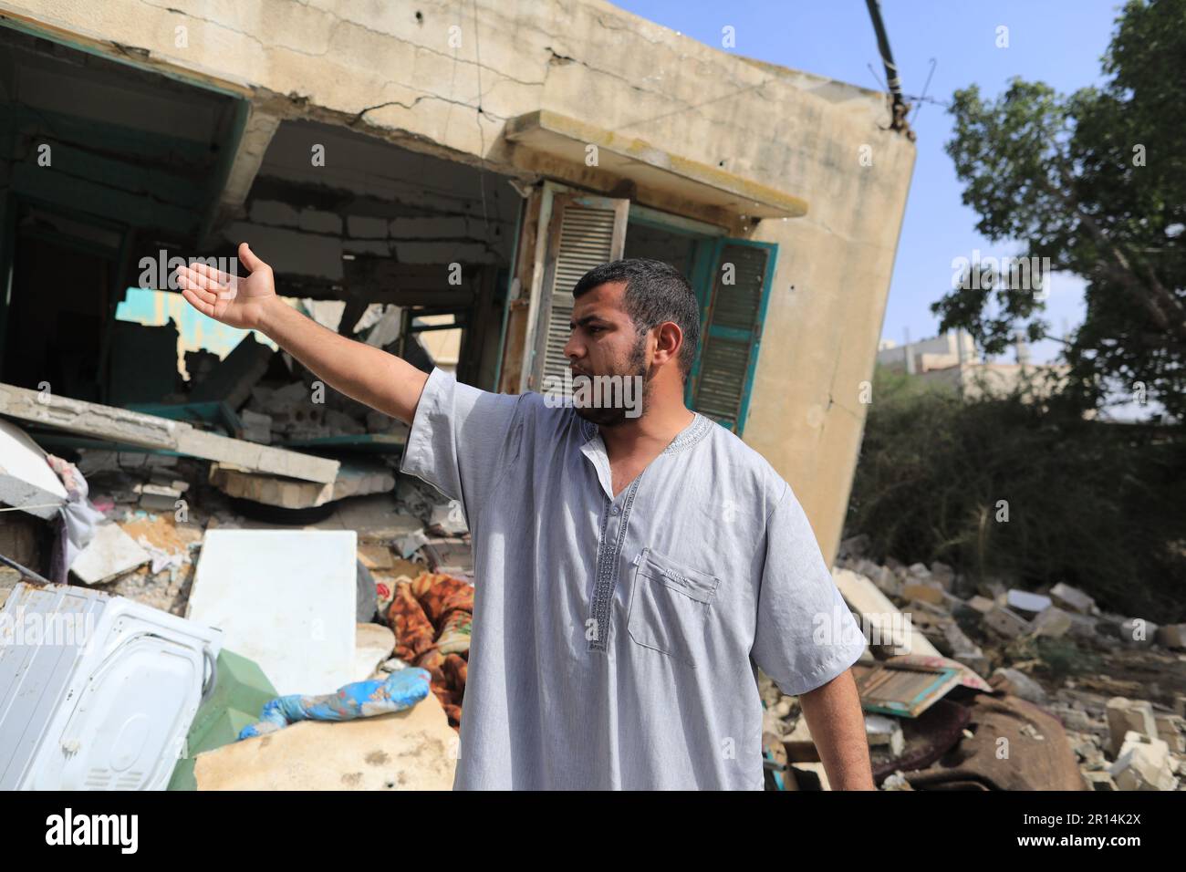 Gaza. 11th May, 2023. A man stands in front of a damaged house ...