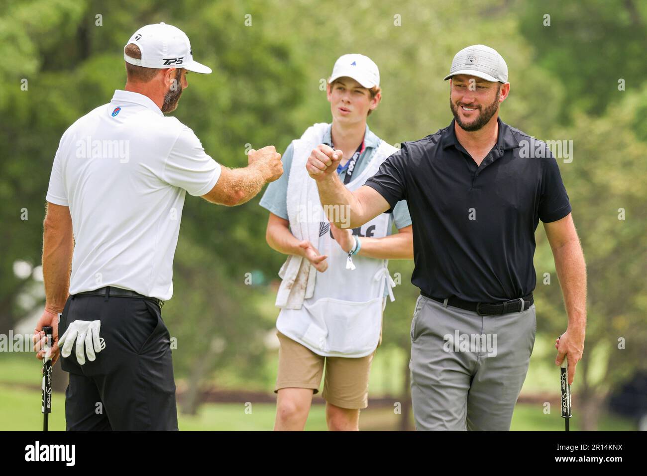 Captain Dustin Johnson of 4Aces GC fist bumps a pro-am participant on ...