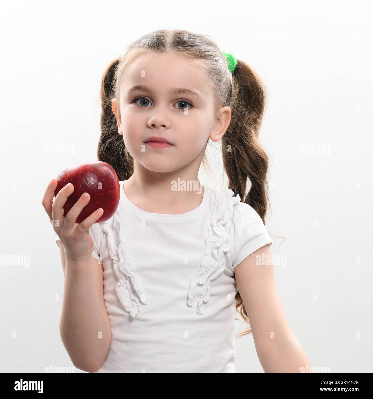Red apple and little girl, portrait of a child on a white background ...