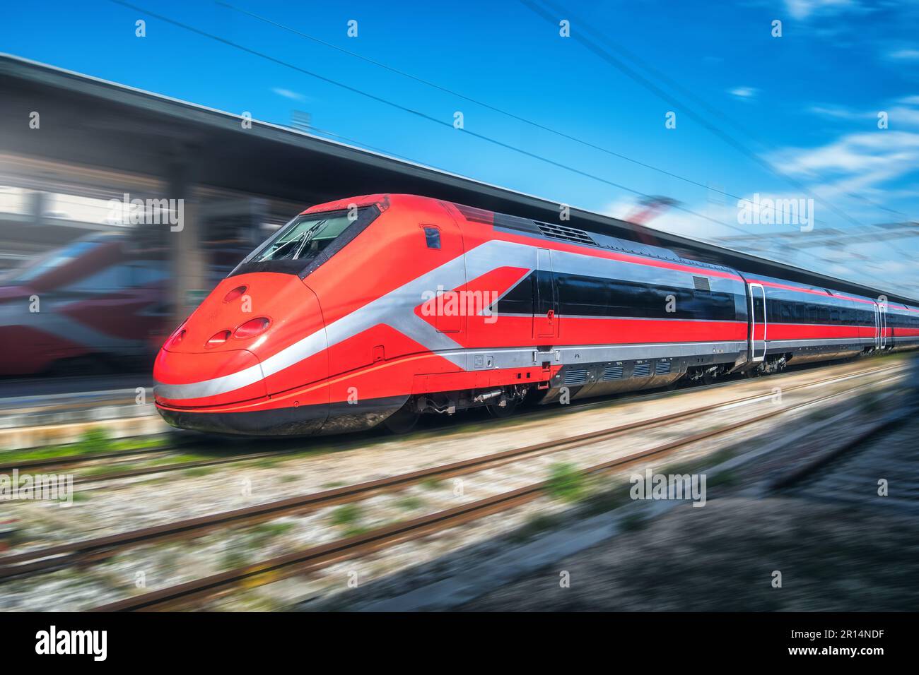 Red high speed train in motion on the railway station Stock Photo - Alamy