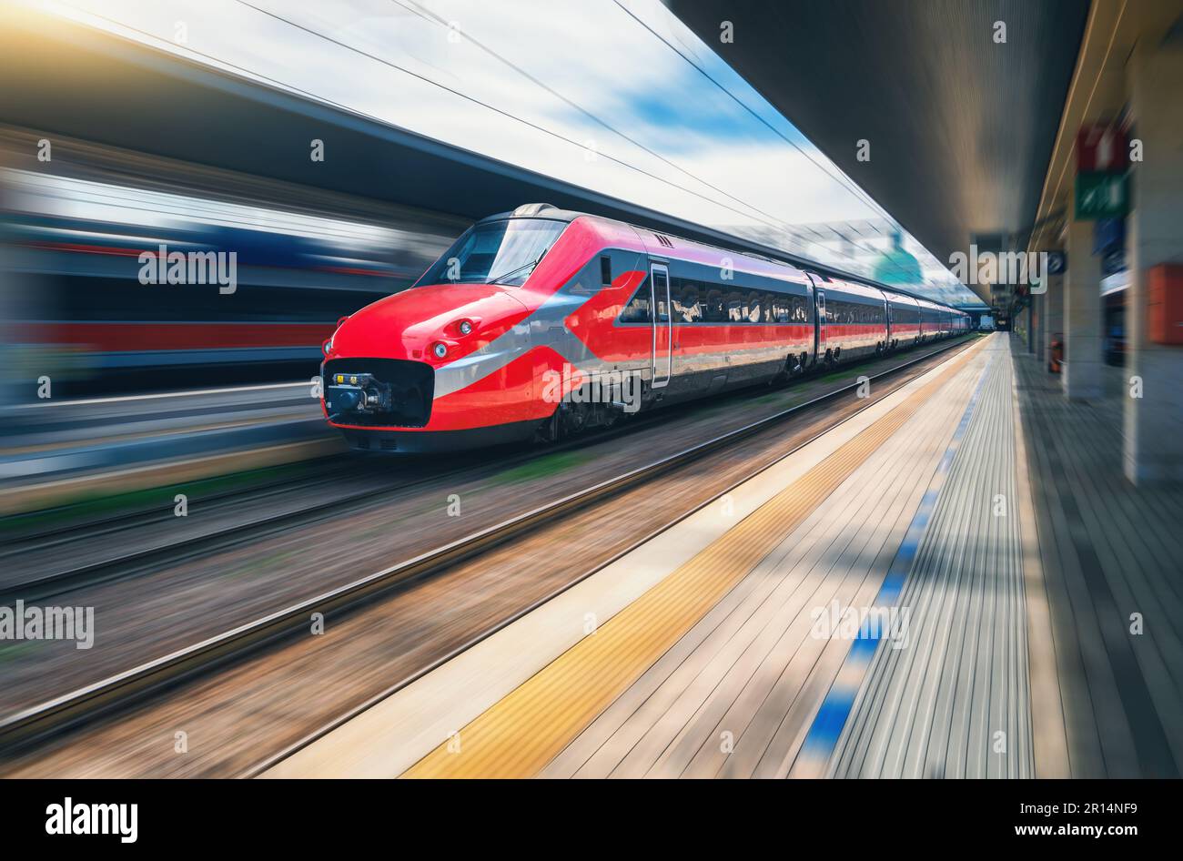 Red high speed train in motion on the railway station Stock Photo - Alamy