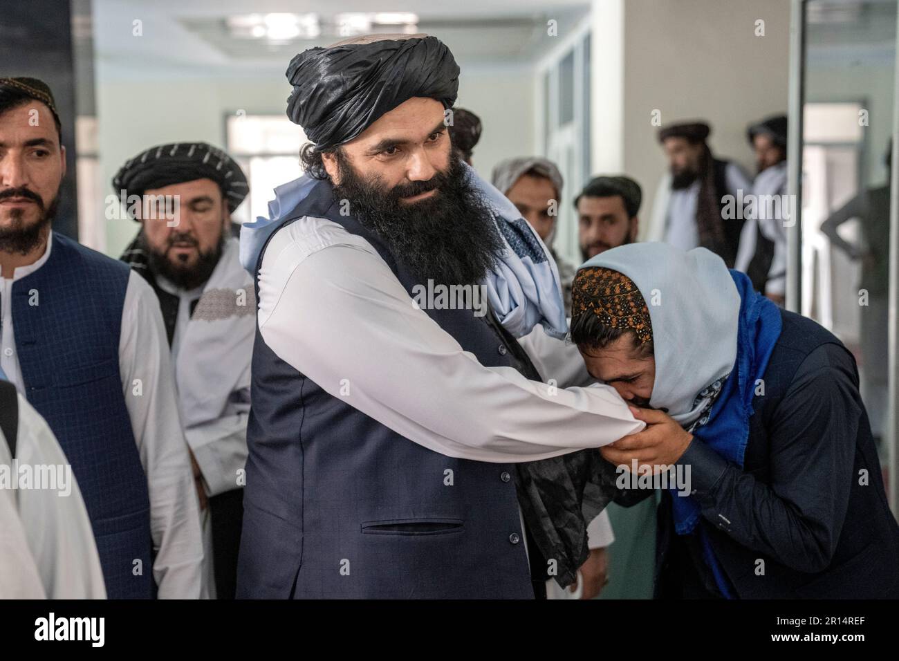 An Afghan man kisses the hand of Taliban's Acting Minister of Interior ...