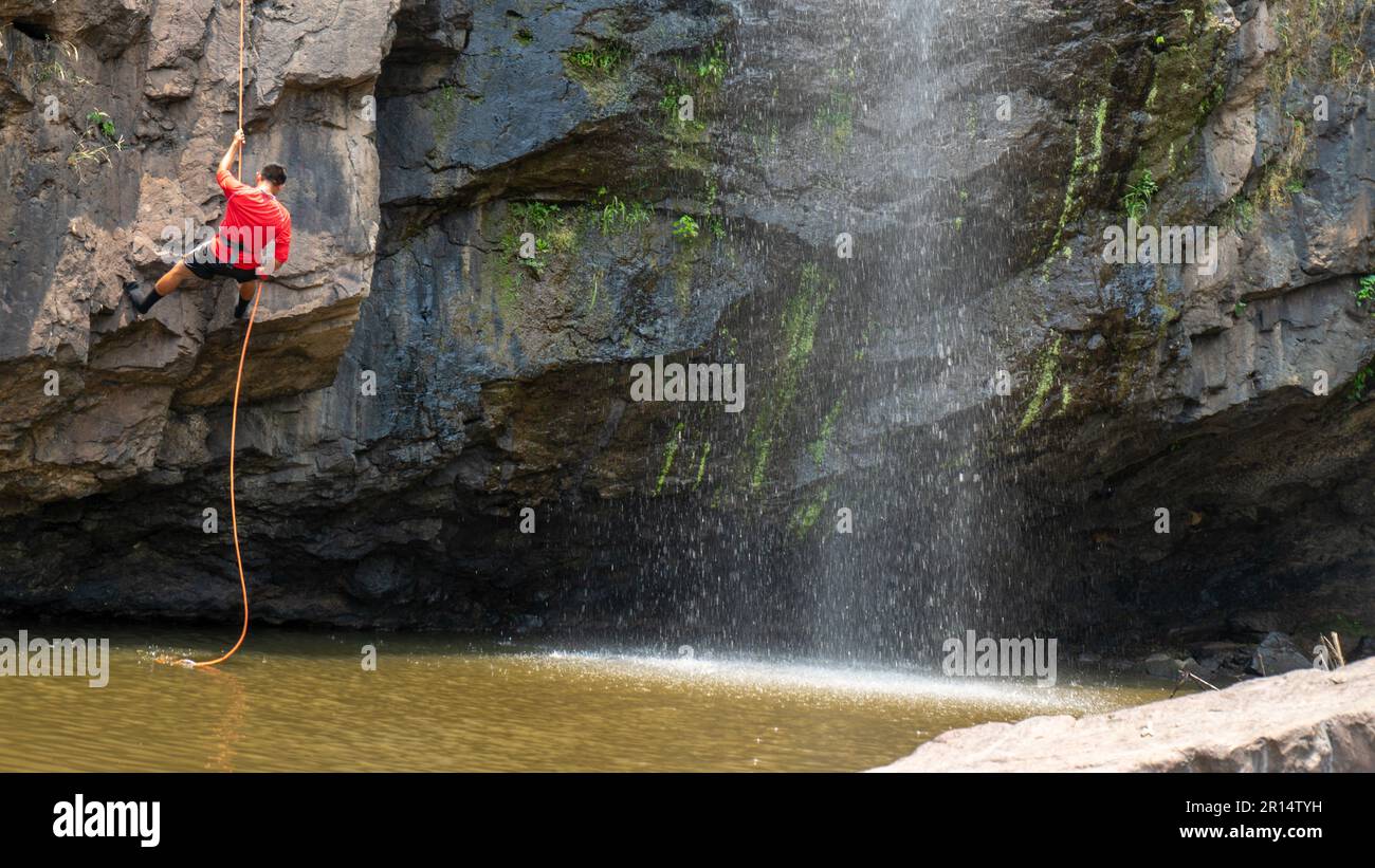 Mountain climbing over a waterfall in Matagalpa, Nicaragua during a ...