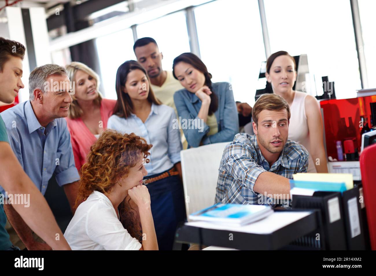 Its pretty easy. a young man explaining something to his colleagues in ...