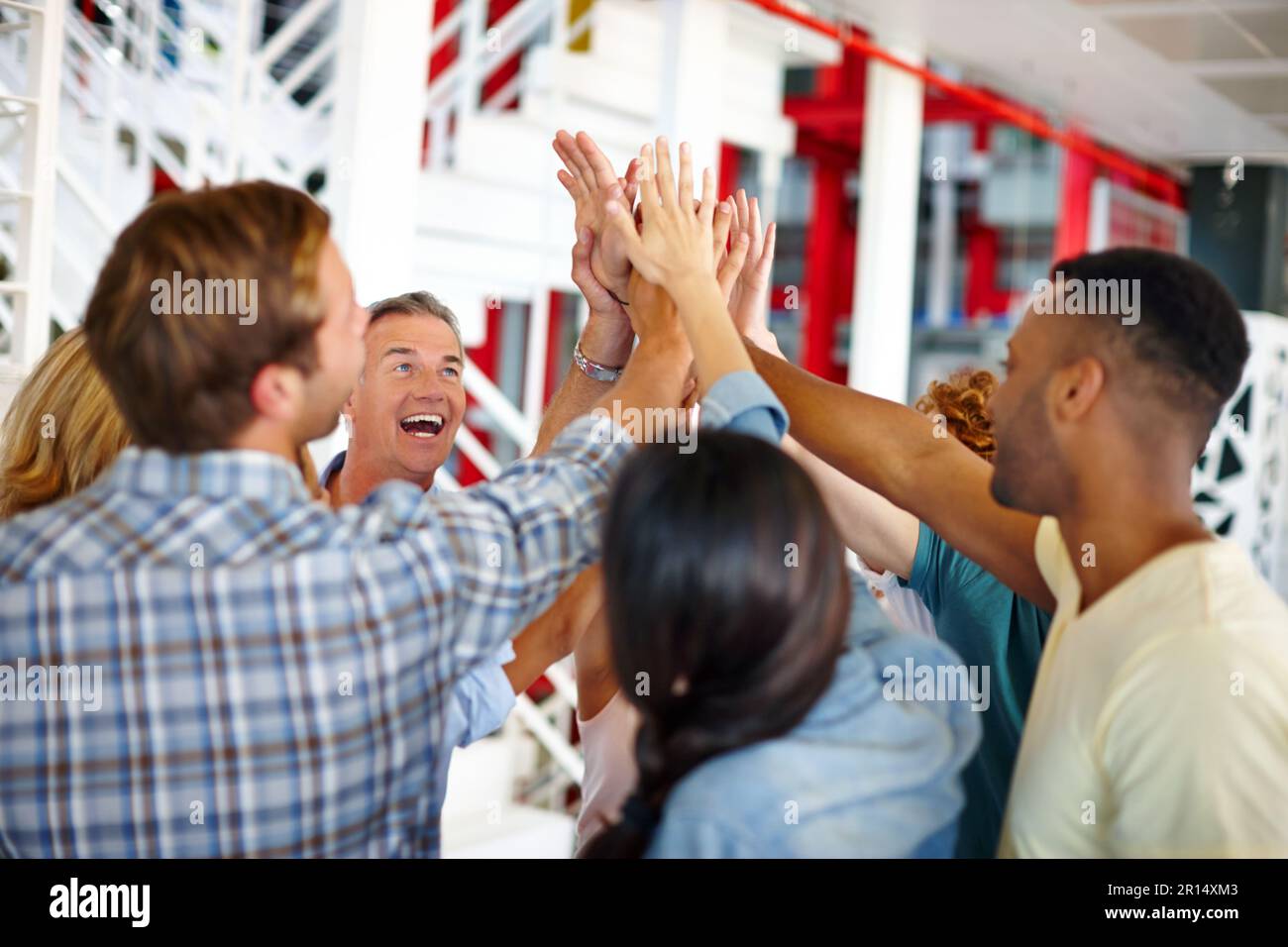 Lets do it for the team. a group of coworkers giving each other a high ...