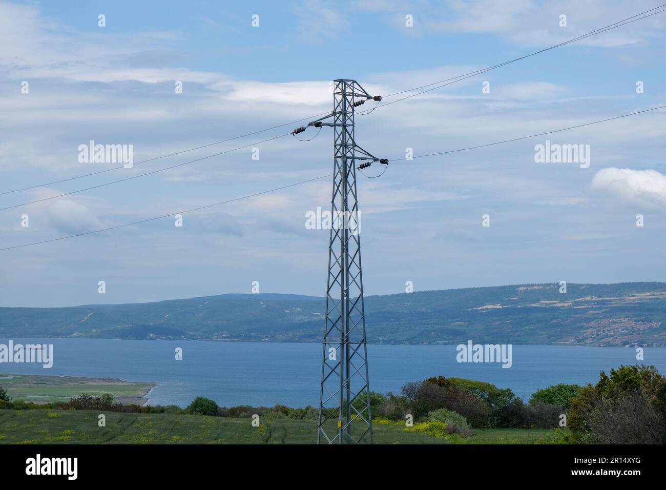 High electricity pylons against the blue sky and sea background. Open ...
