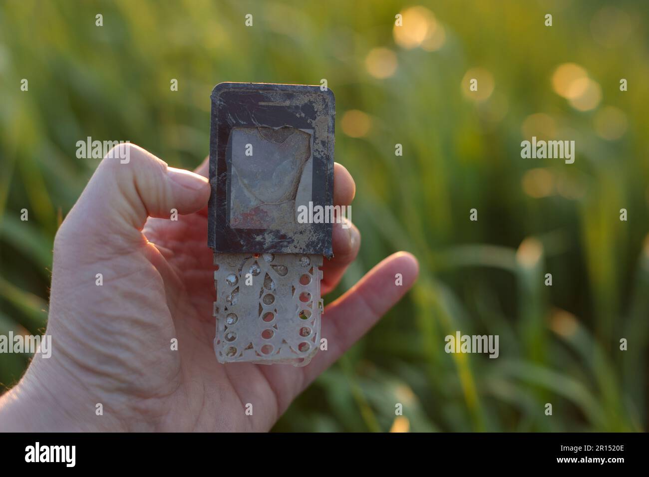 Damaged phone held in hand - e-waste disposal challenge concept Stock ...