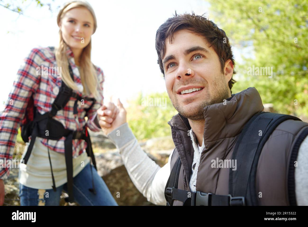 Careful now, watch your step...A handsome young hiker helping his ...