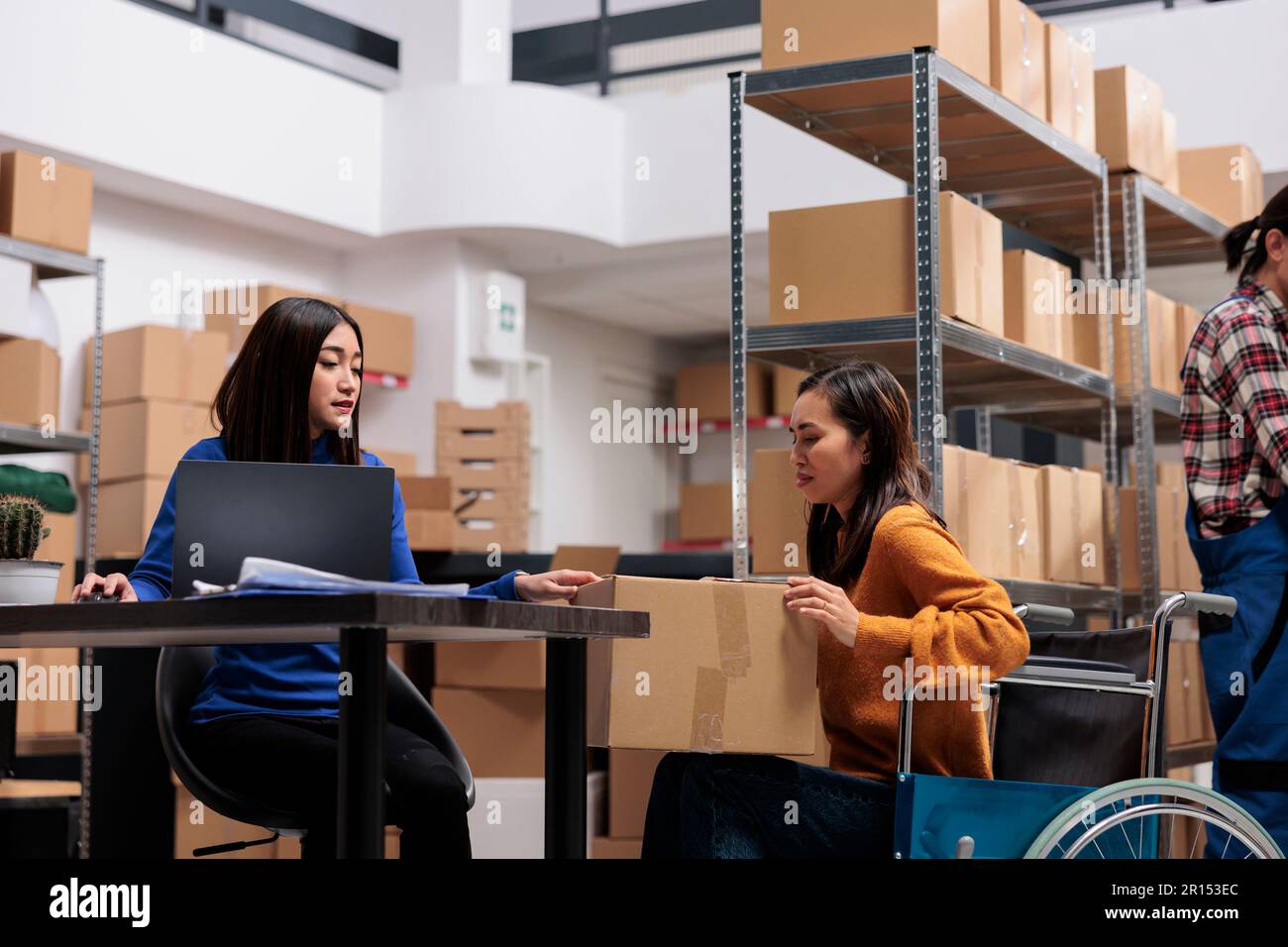 Warehouse asian women employees managing package distribution in ...