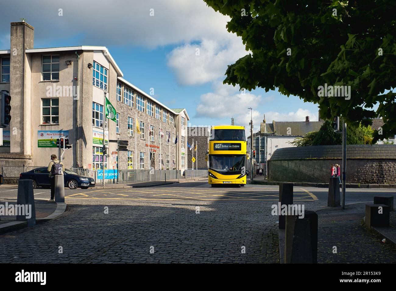City scene with yellow bus driving at St. Francis Street in Galway city ...