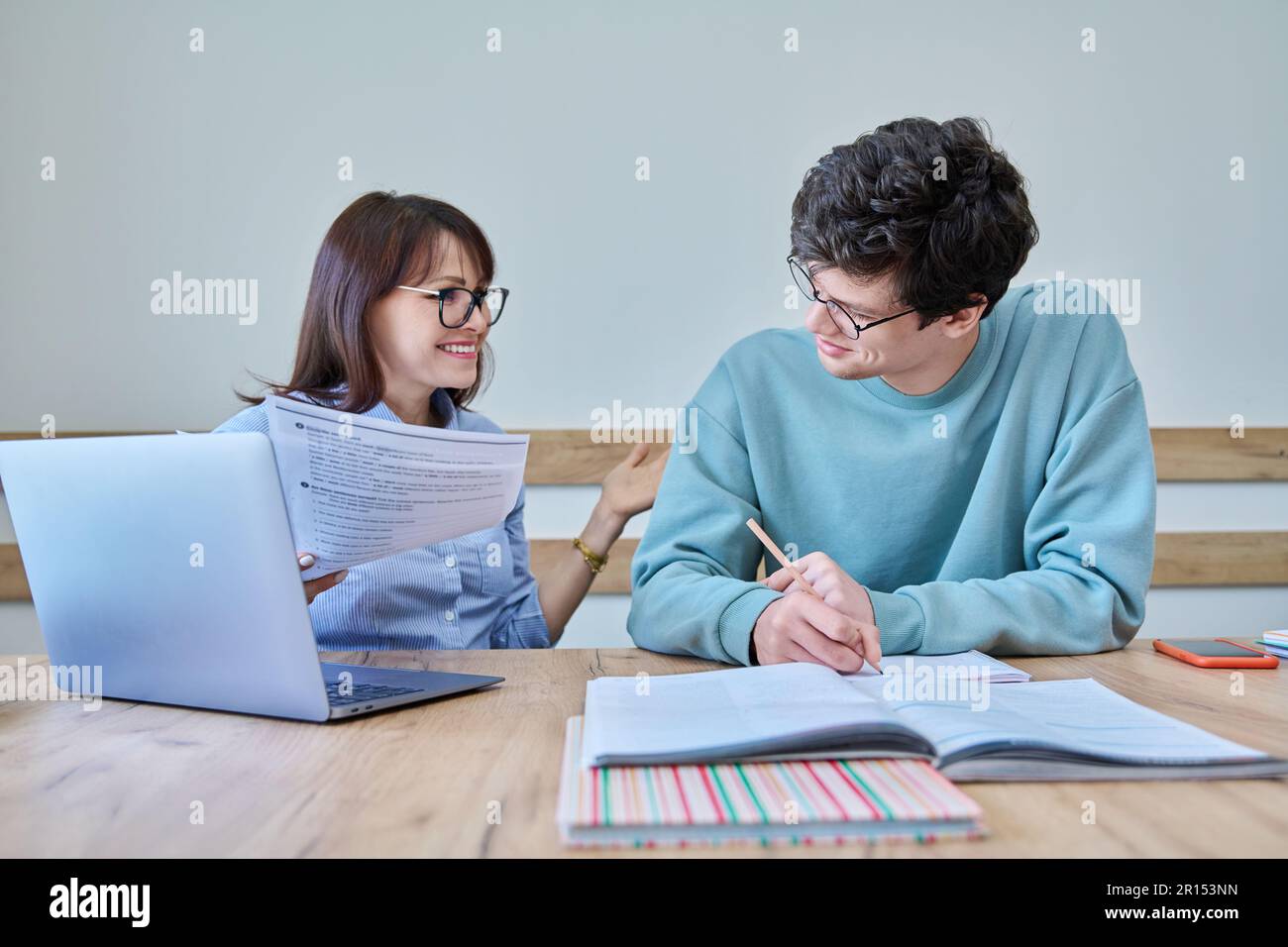 Young teenage male studying languages with teacher in classroom Stock ...