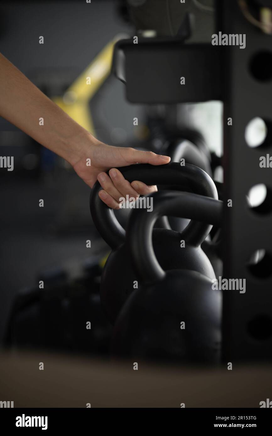 detail of hand taking a circular dumbbell from gym, sports equipment ...