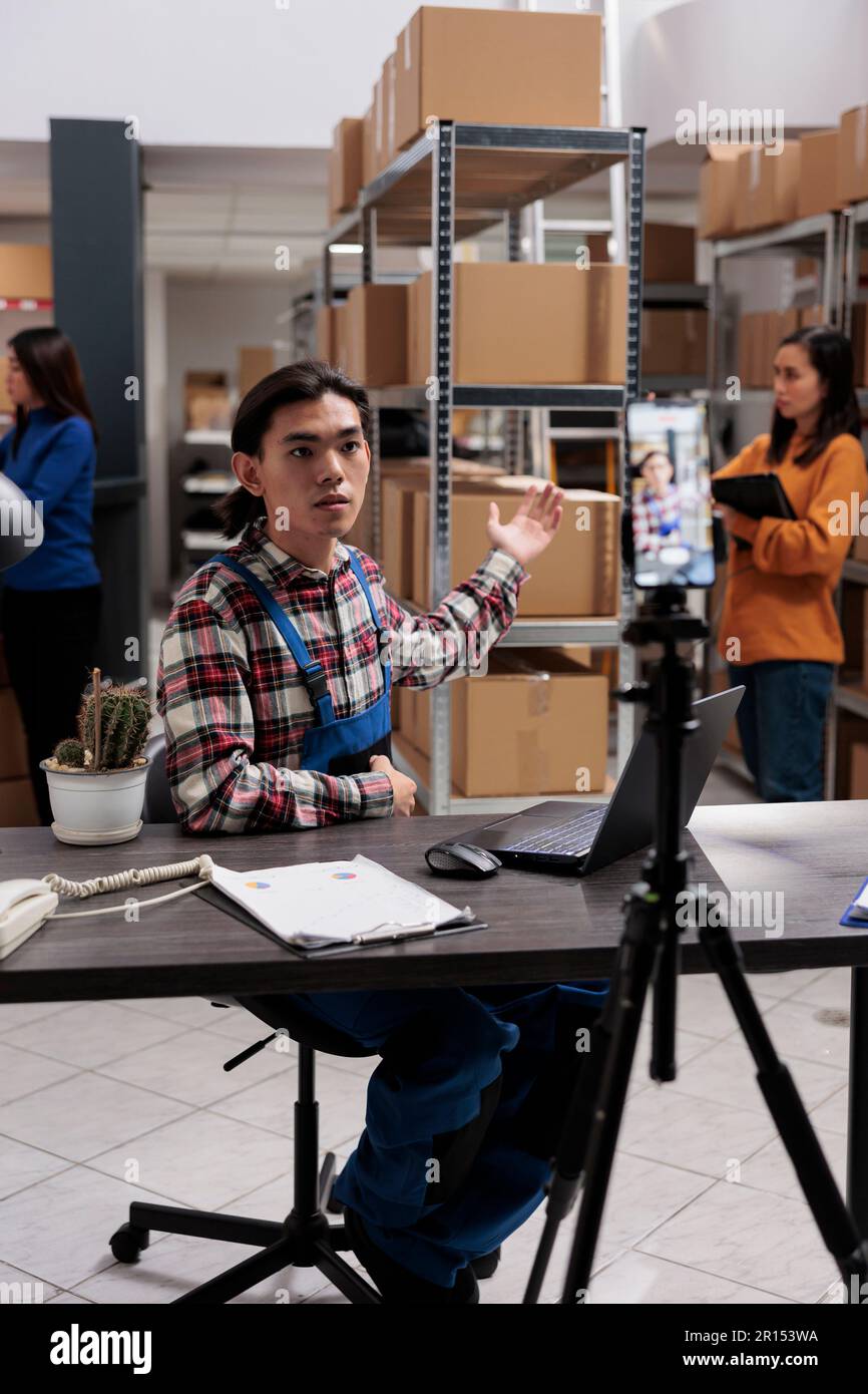 Post office warehouse worker recording smartphone video with stock ...