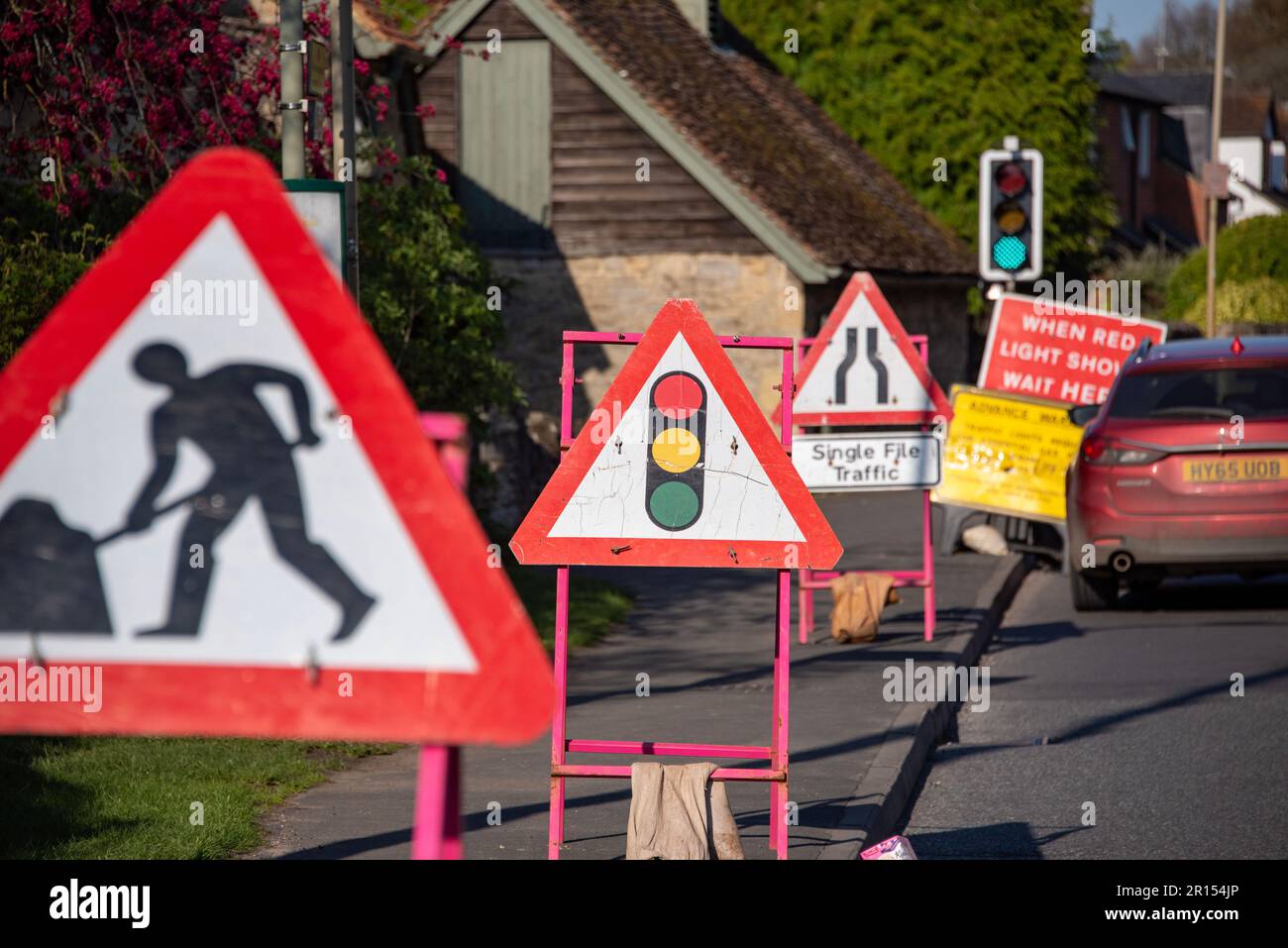 Roadworks signs and temporary traffic lights Stock Photo - Alamy