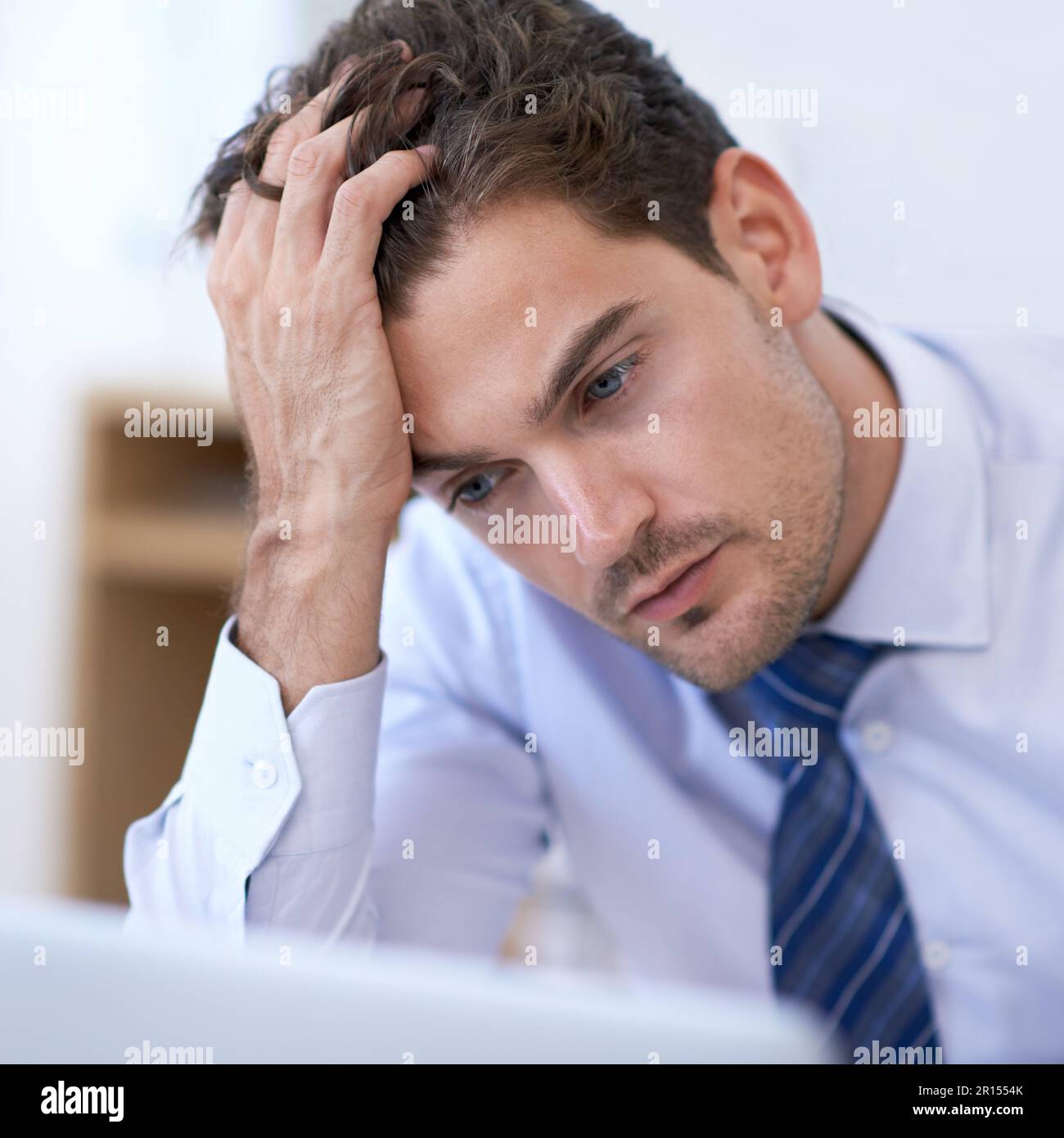 Work getting you down. a frustrated young businessman in the office ...